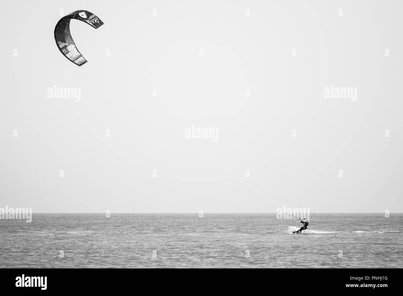 Kiteboarder pulling tricks and getting air on a bright summers day with ...