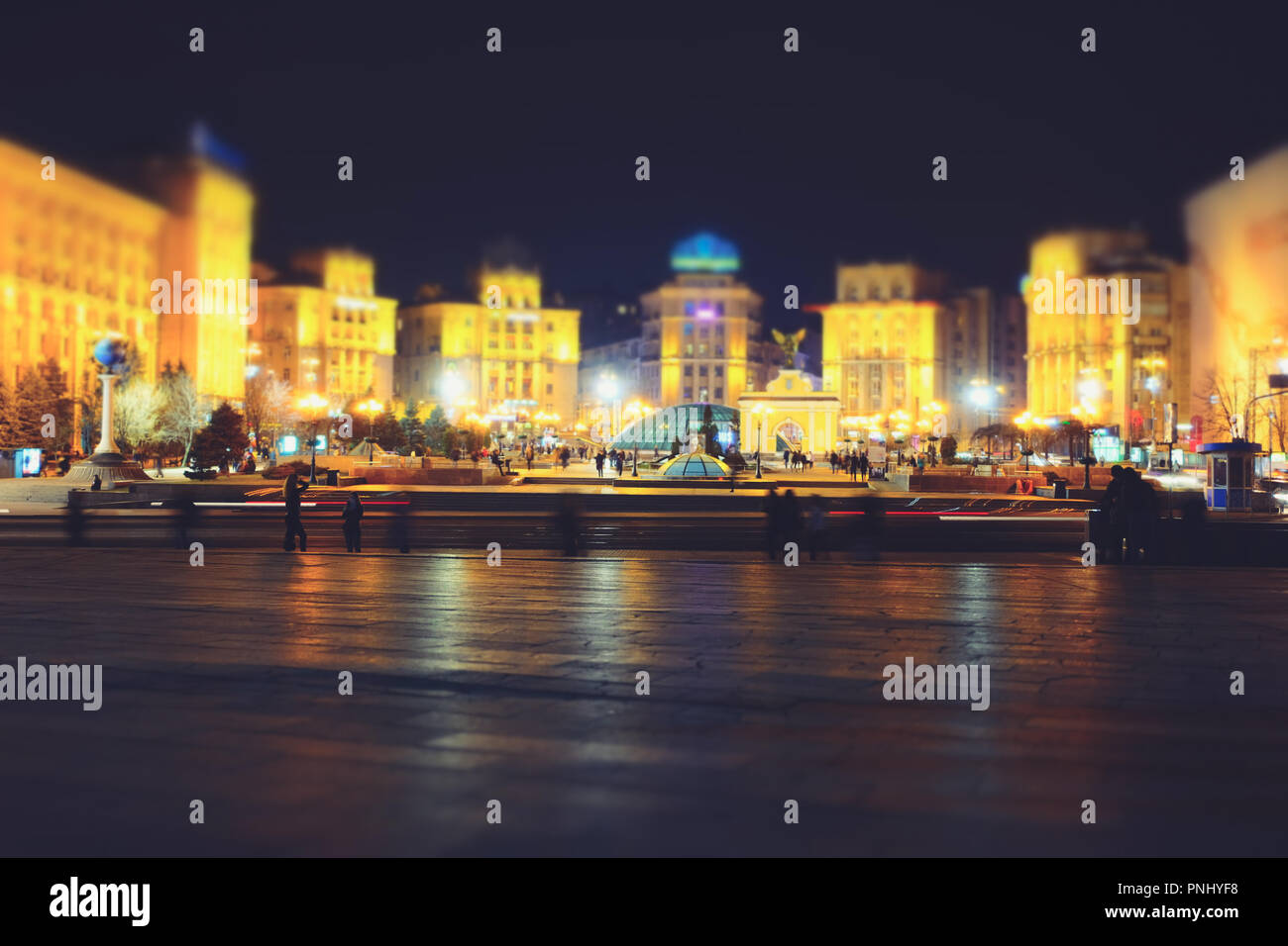 Night city street with cars on the road and walking people, tilt-shift ...