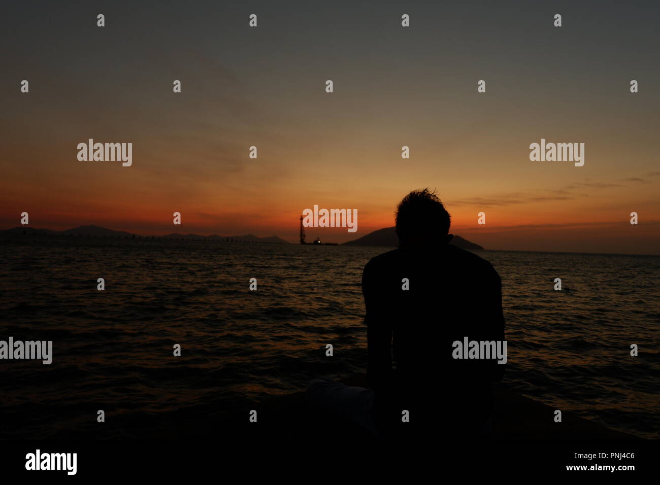 Man watching sunset at the beach hi-res stock photography and images ...