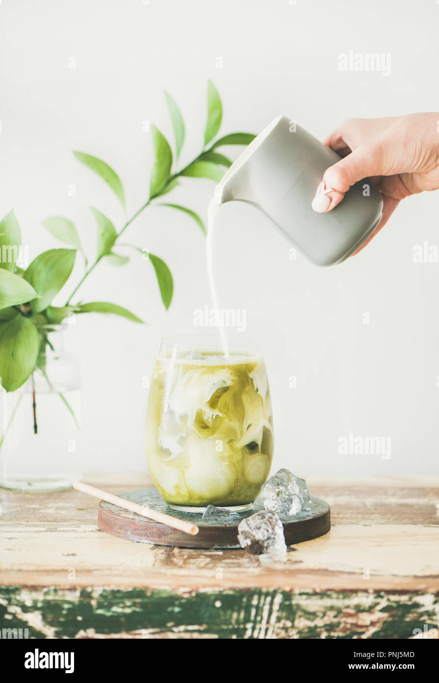 Iced matcha latte with milk pouring fron pitcher in glass Stock Photo ...