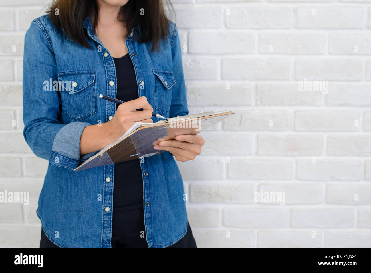Woman hands holding a notebook and a pen ready to take notes standing ...