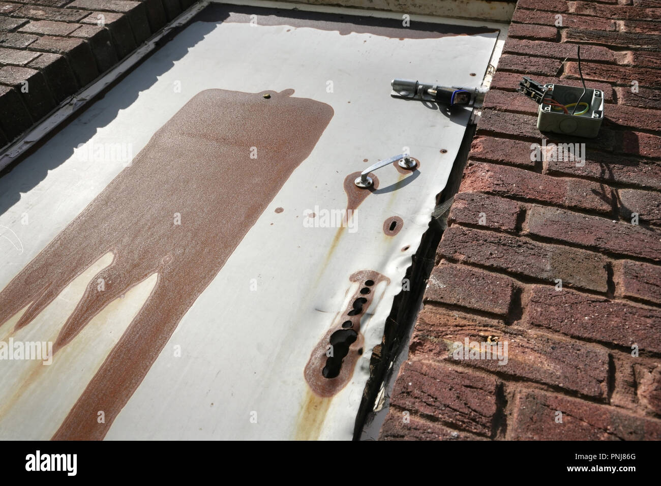 Damaged metal door into abandoned industrial building Stock Photo - Alamy