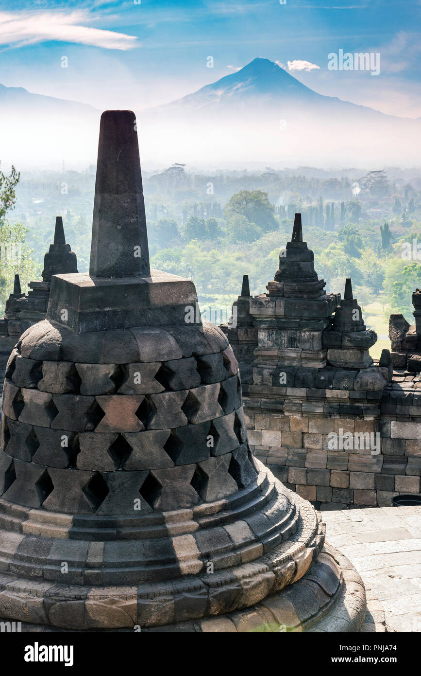 Buddha statue with Mount Merapi in the background, Candi Borobudur ...