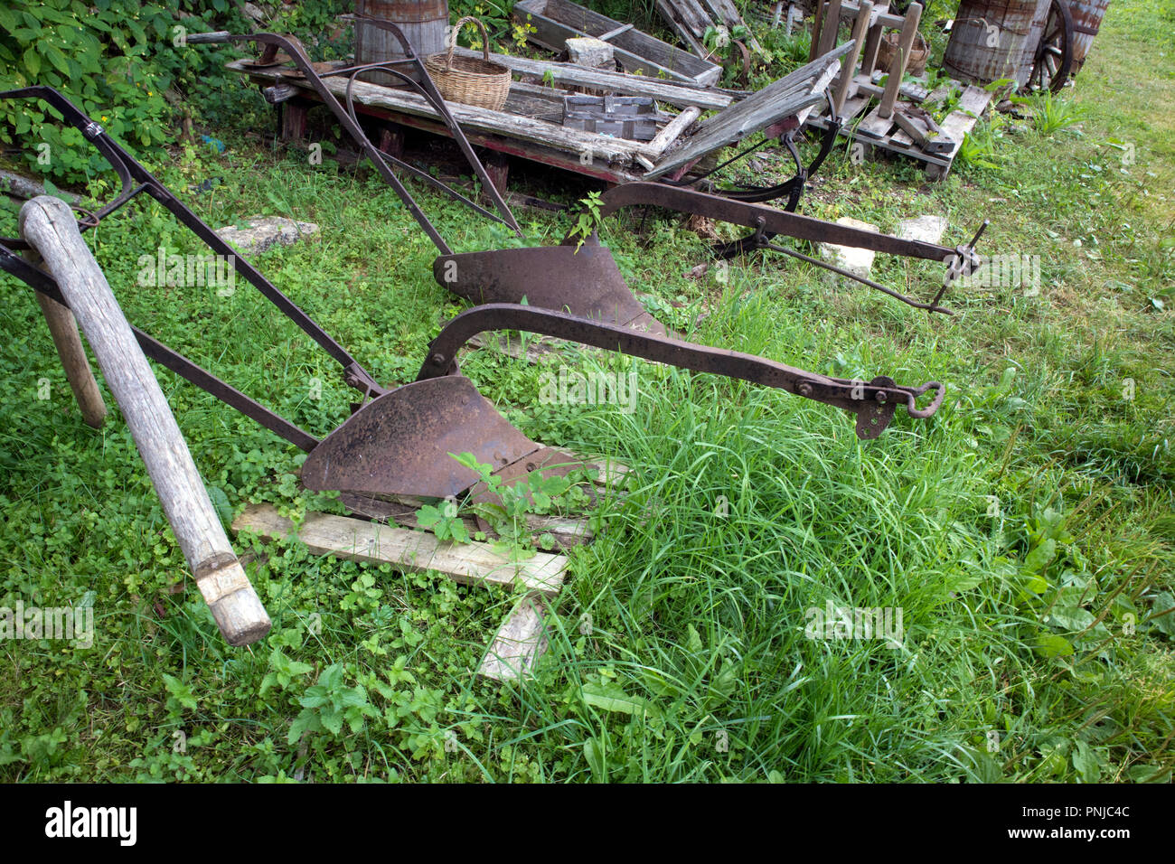 Open air museum of antique peasant things, old rusty plows on the grass ...