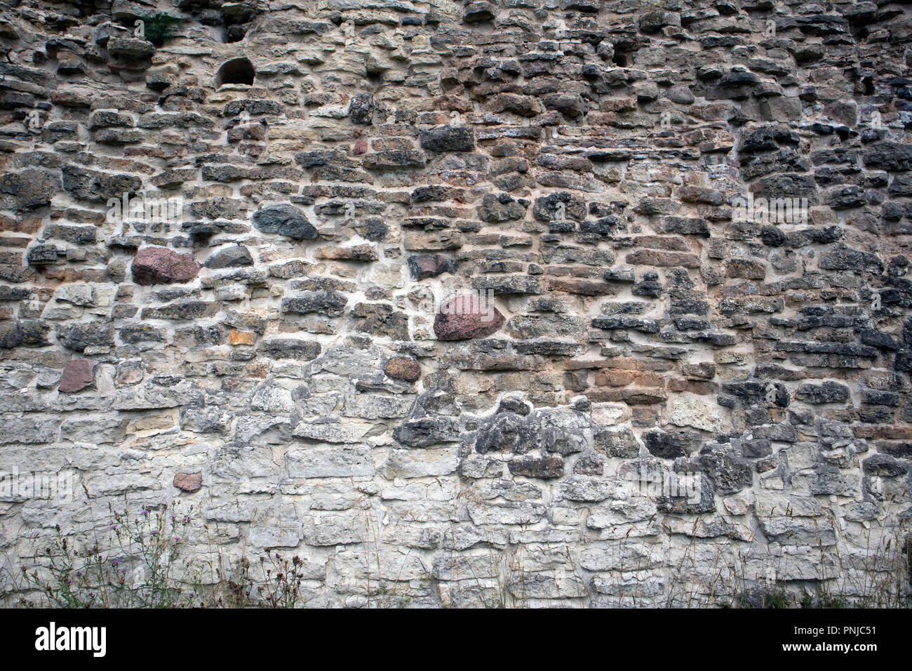 Antique masonry, fragment of ancient crumbling fortress wall of granite ...