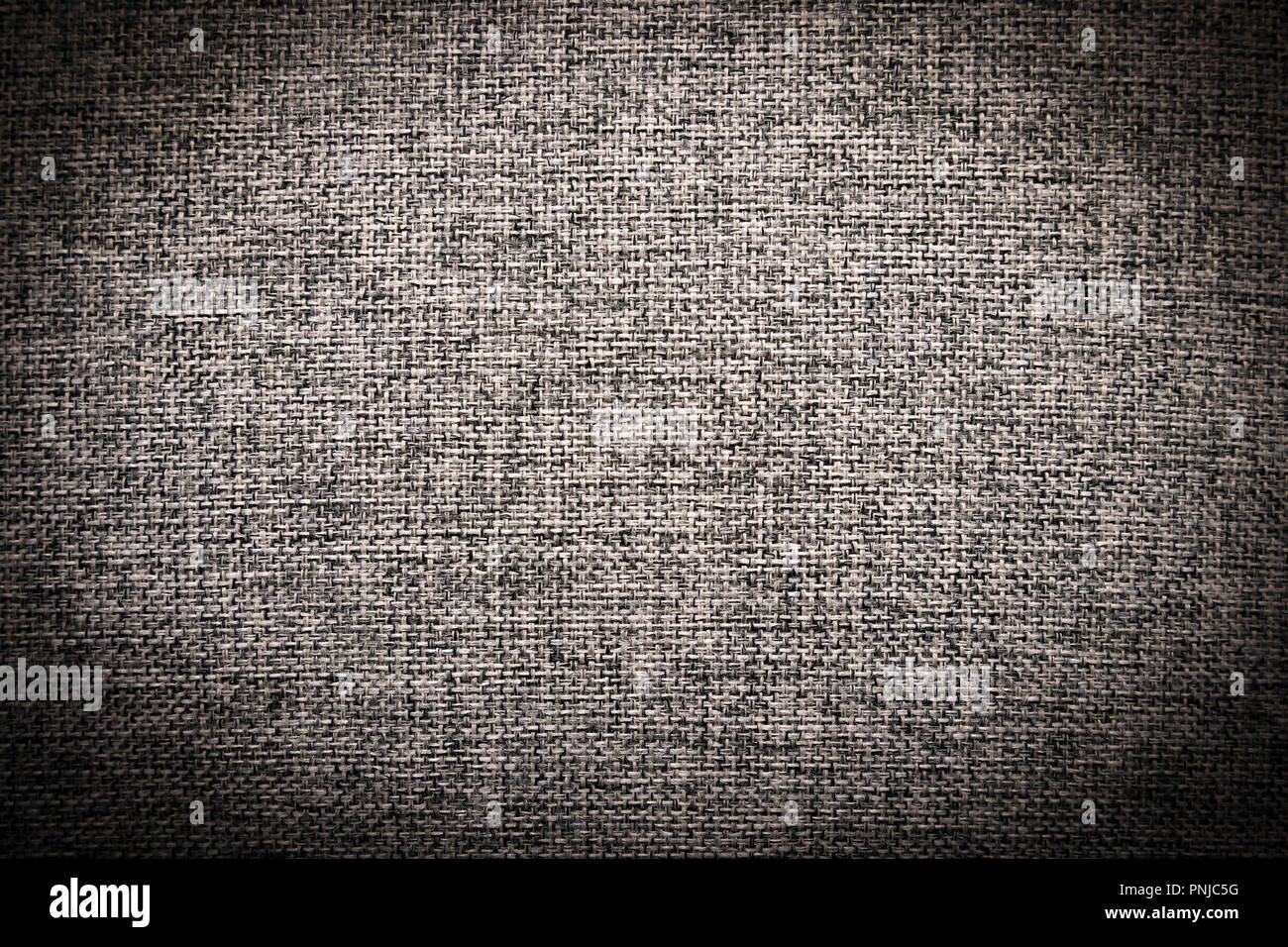 Grey textile interlaced pattern closeup, background with darkened ...