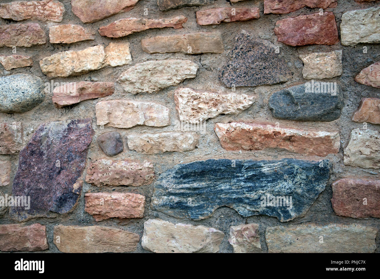 Stone texture, fragment of ancient crumbling fortress wall of granite ...