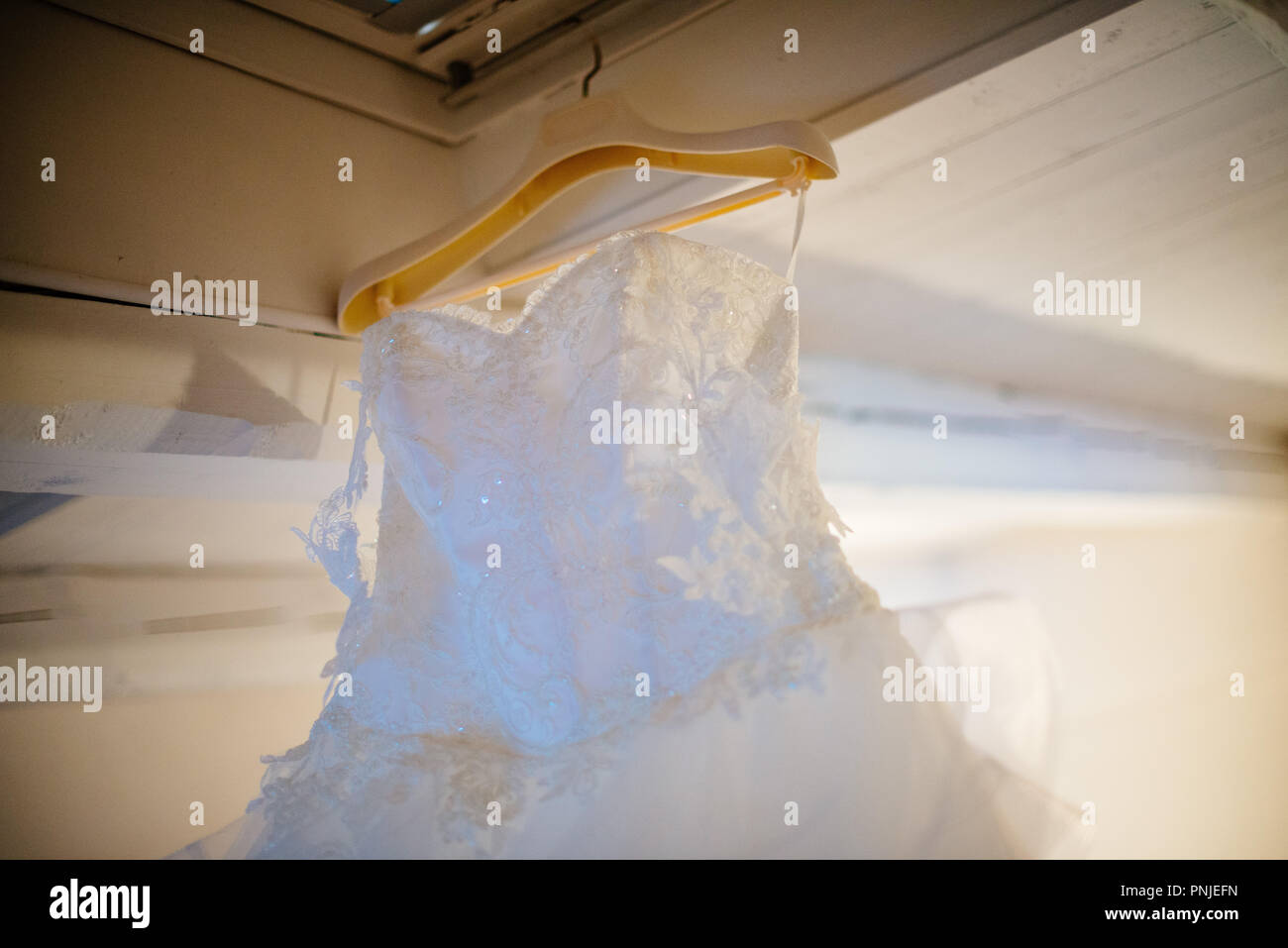 wedding dress hanging waiting for the bride's dressing Stock Photo - Alamy