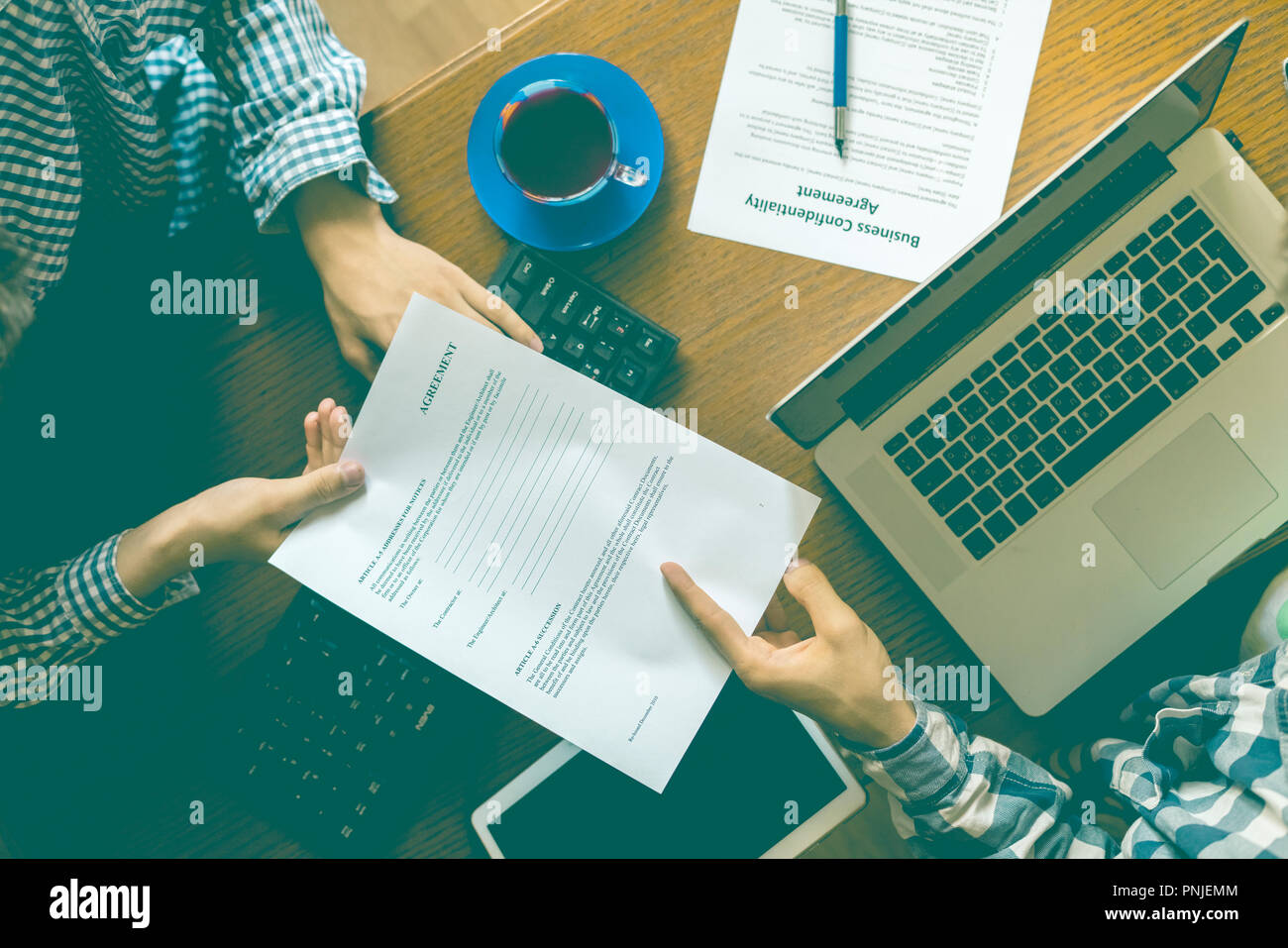 two business partners sign partnership agreement in the office table ...
