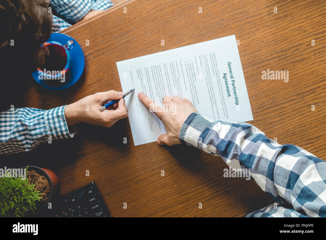 two business partners sign partnership agreement in the office table ...