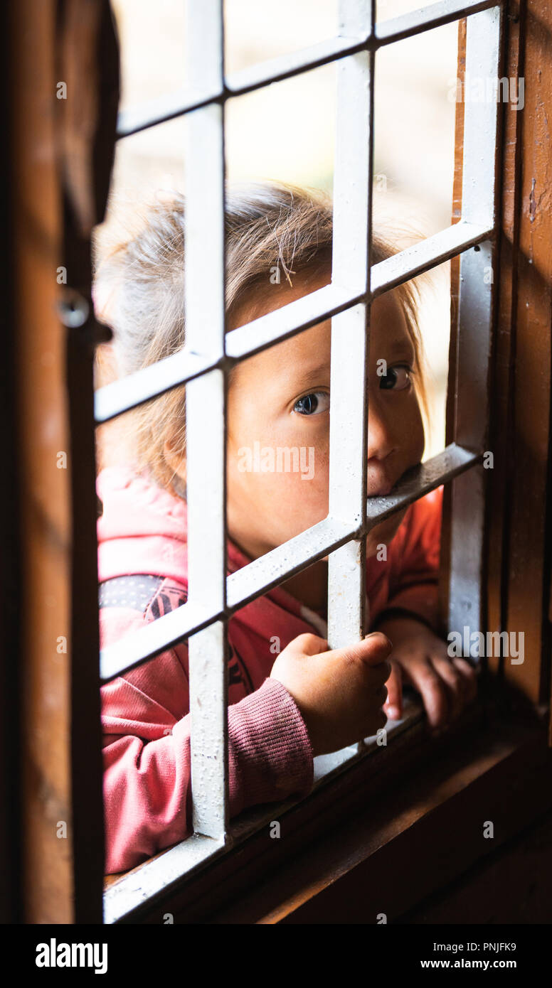 GHALEGAUN, NEPAL - CIRCA MAY 2018: Young Nepali girl looking through an ...