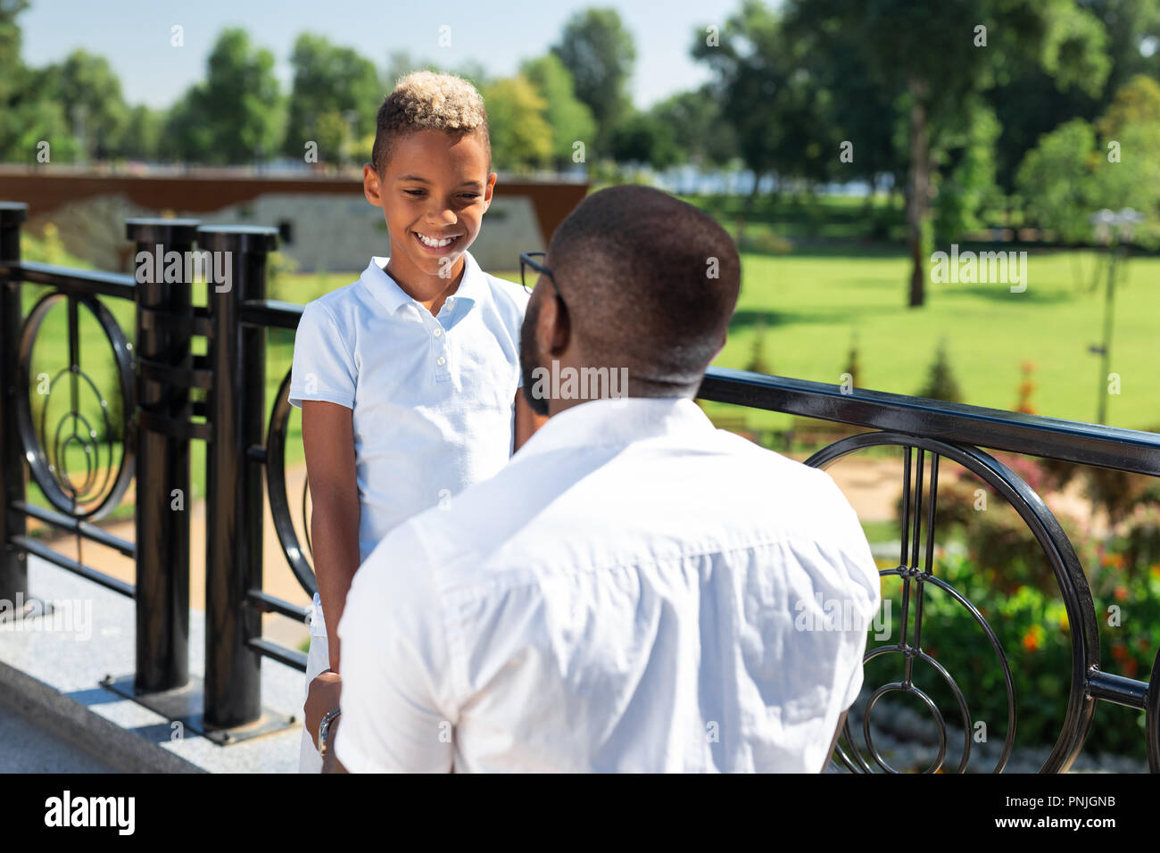 Cheerful nice boy smiling to his father Stock Photo - Alamy