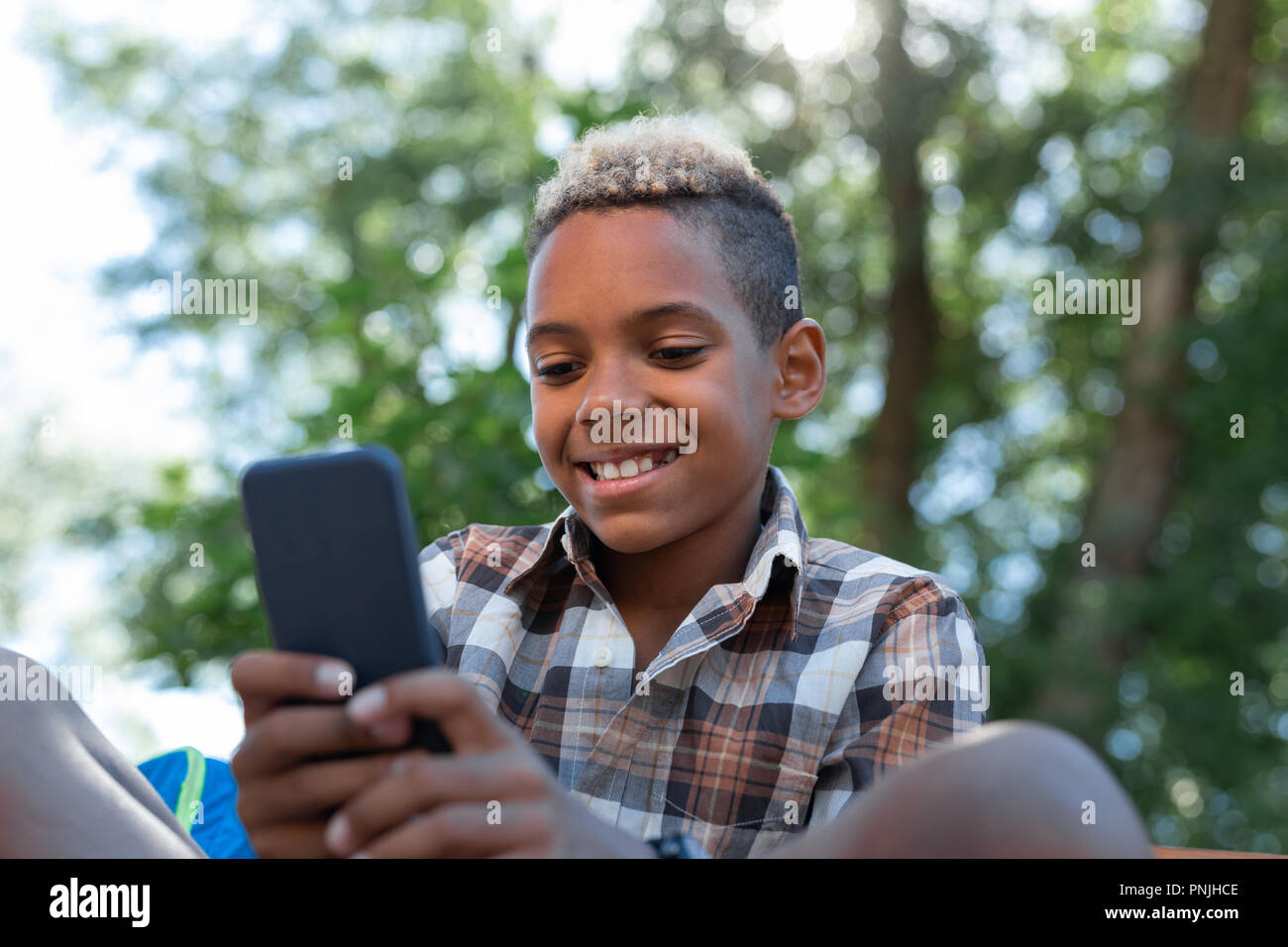 Delighted positive nice boy typing a message Stock Photo - Alamy