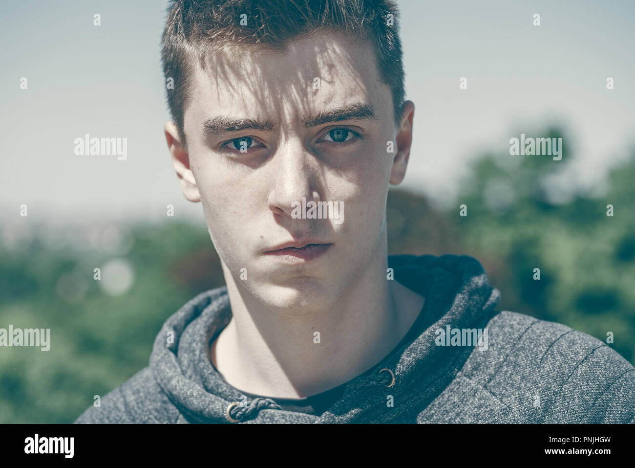portrait of a serious young man with blurred background Stock Photo - Alamy