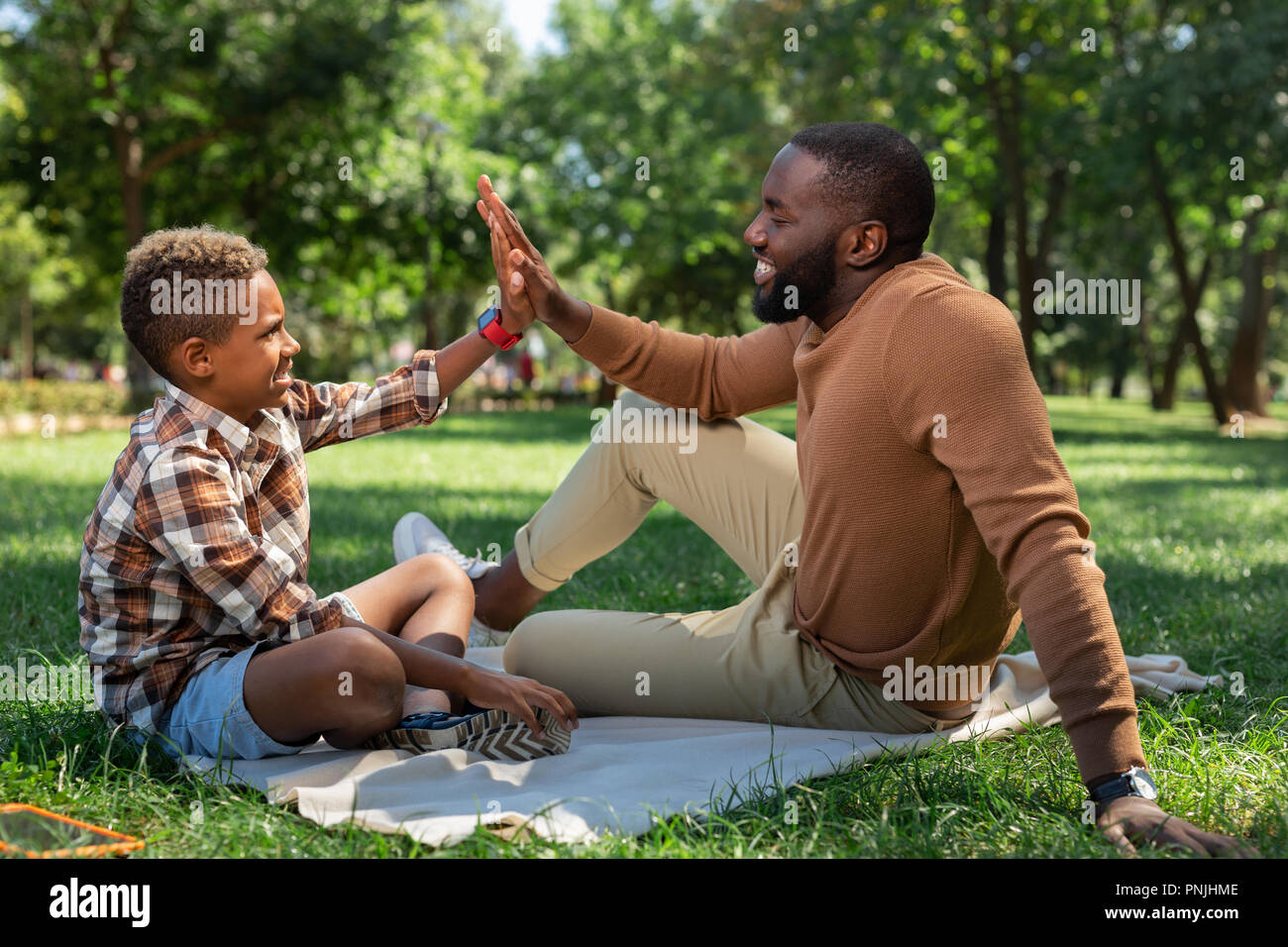 Delighted happy father and son giving high five Stock Photo - Alamy