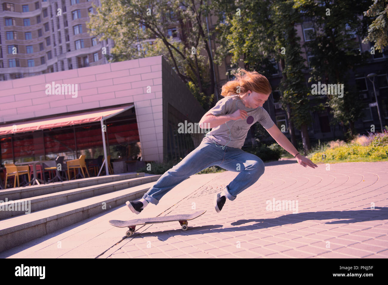 Concentrated longhaired man going to fall on floor Stock Photo - Alamy