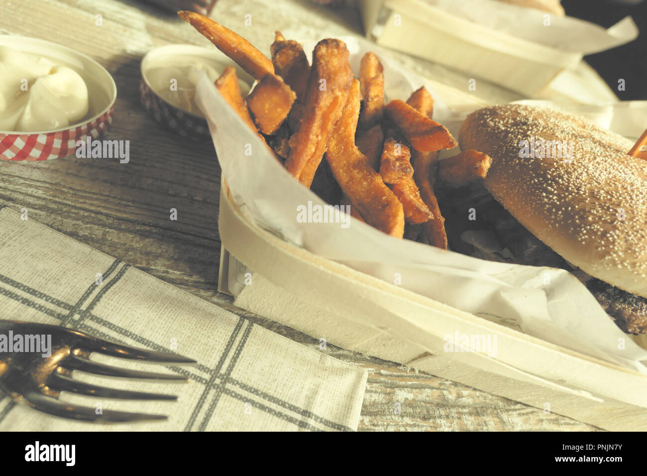 eating fast food burger and fries. cross processed colors Stock Photo ...
