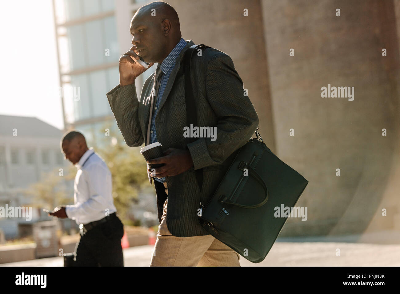 Men using mobile phone while commuting to office. Businessmen leading a ...