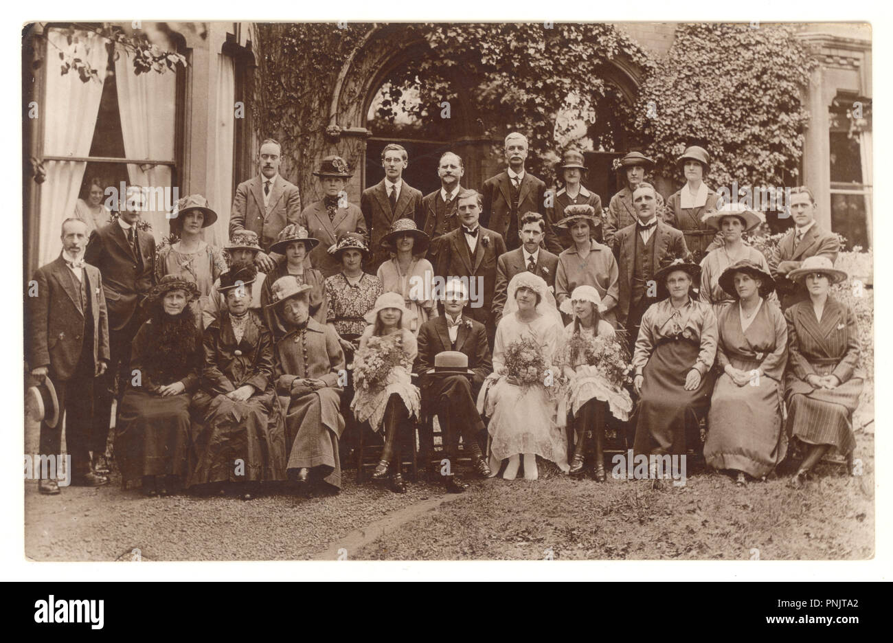 Early 1900's sepia postcard of wedding group with bride and groom. The ...