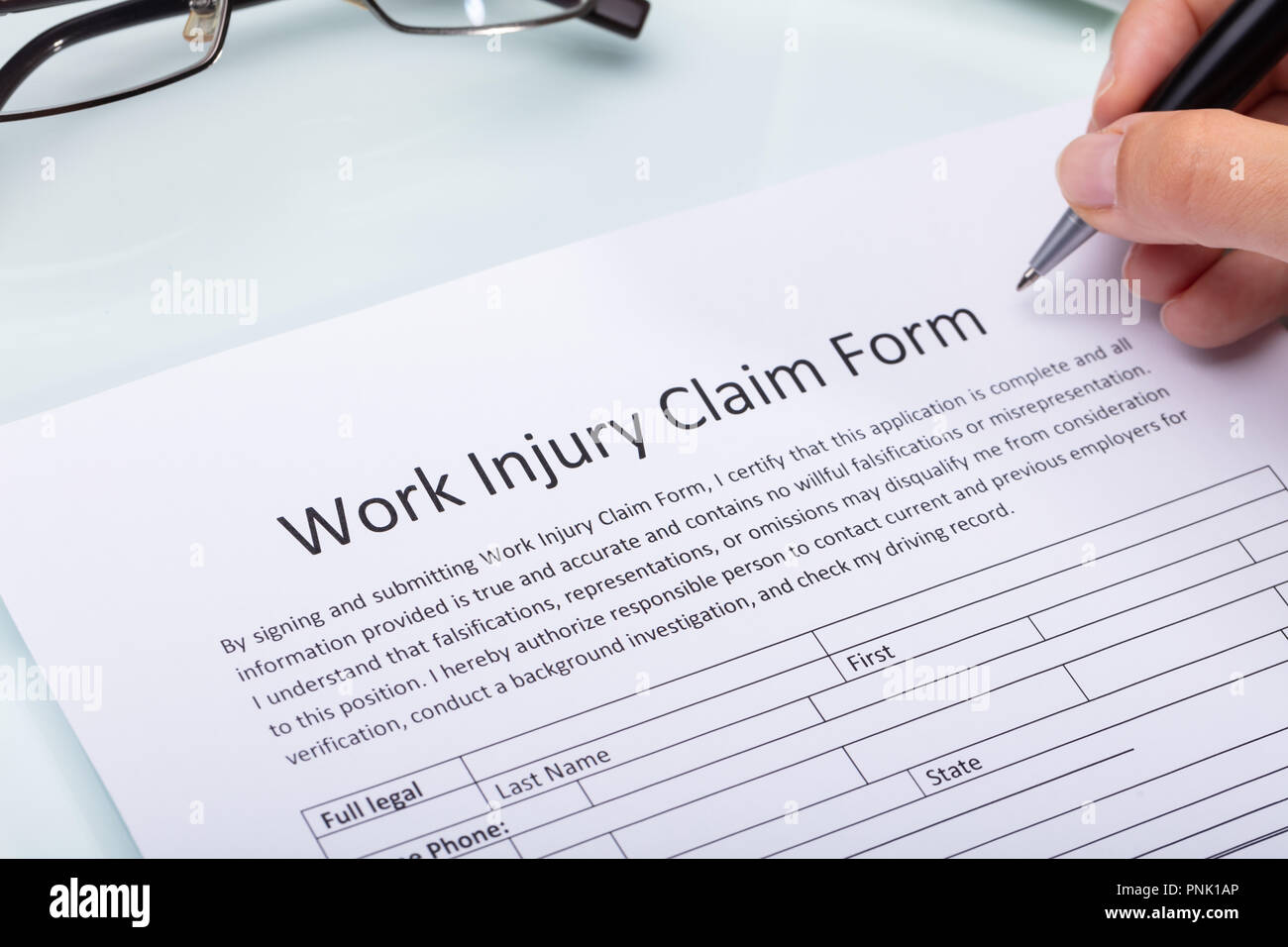 Close-up Of A Woman's Hand Filling Work Injury Claim Form Stock Photo ...