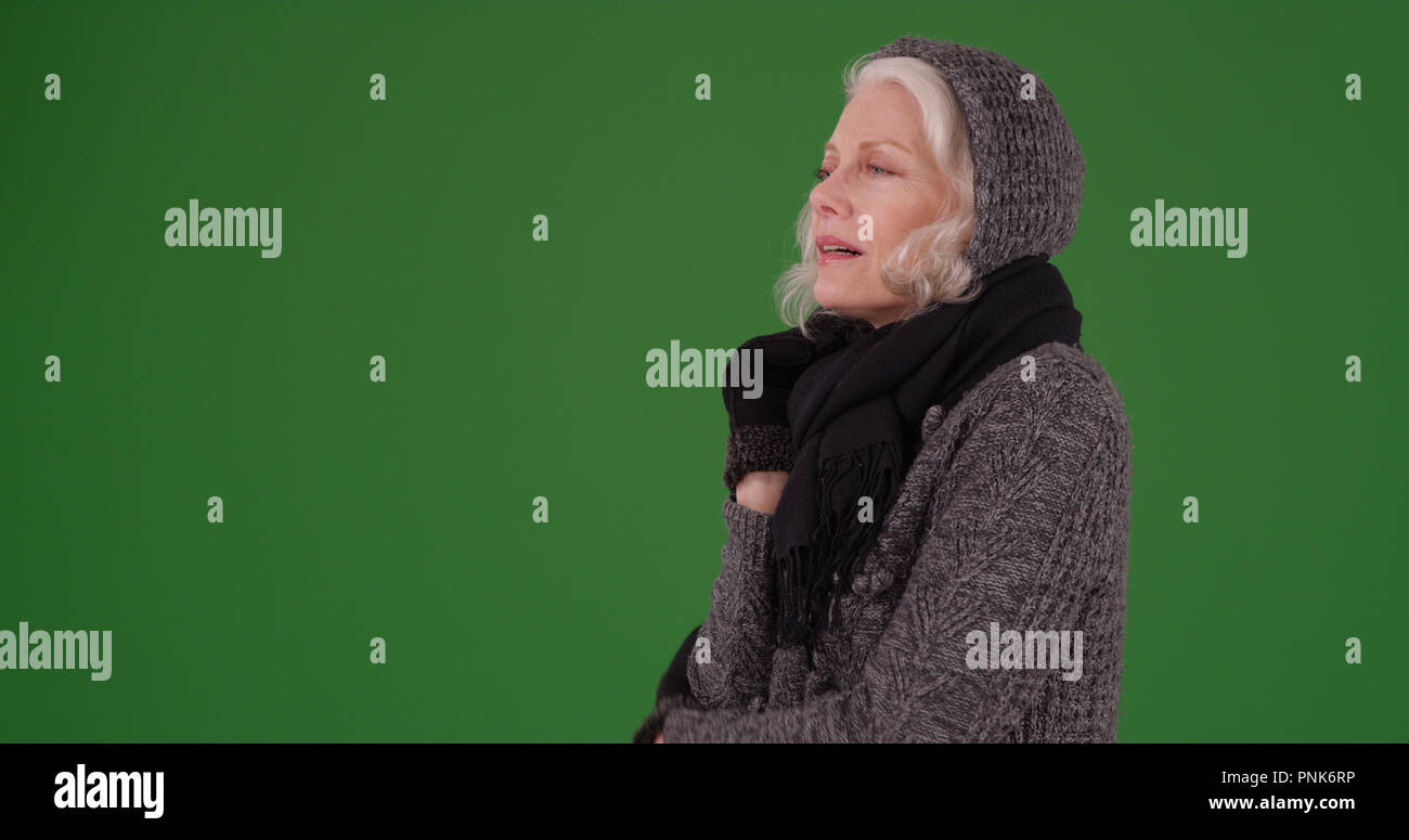 Mature Caucasian female shivering in cold weather on green screen Stock ...