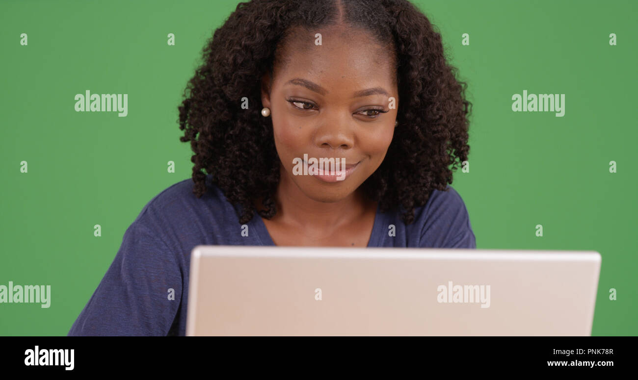 African American woman working on laptop computer on green screen Stock ...