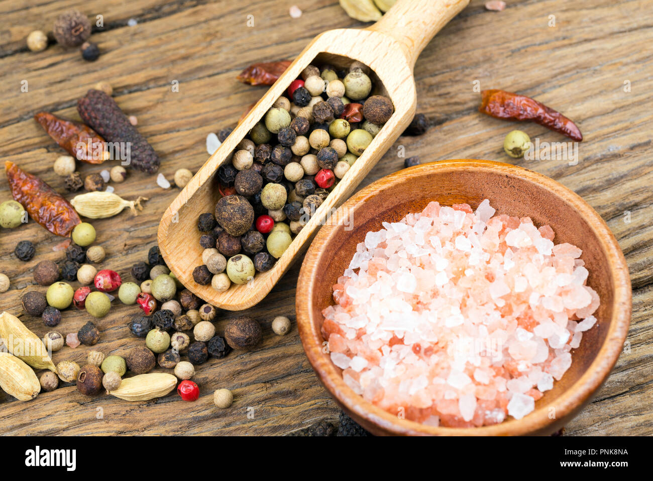 Closeup of colorful peppercorns on a spice scoop and rose crystal salt ...