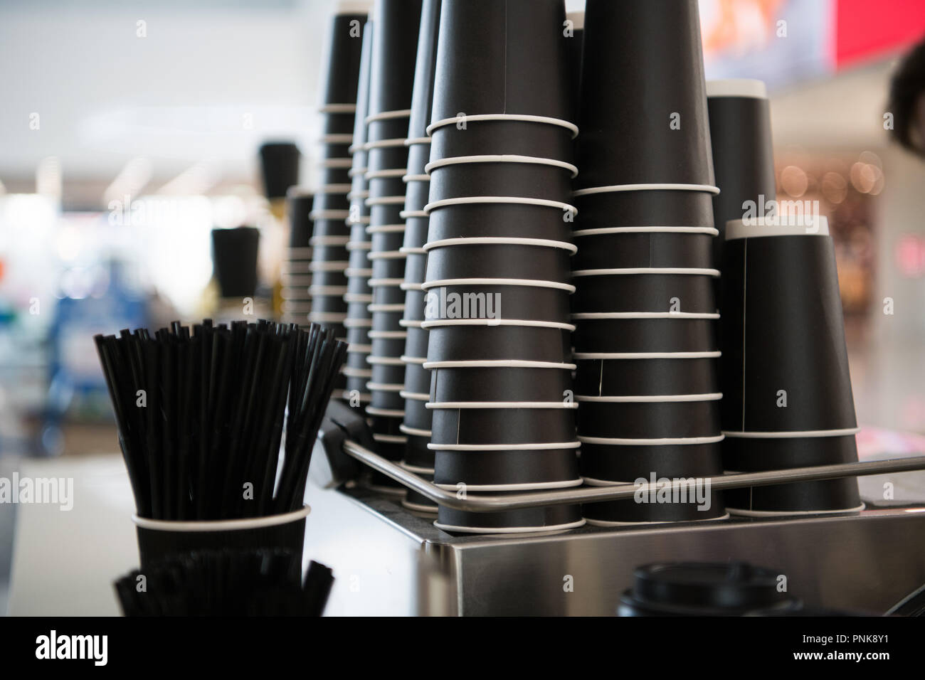 Black paper cups on a counter against the background of a blurred ...