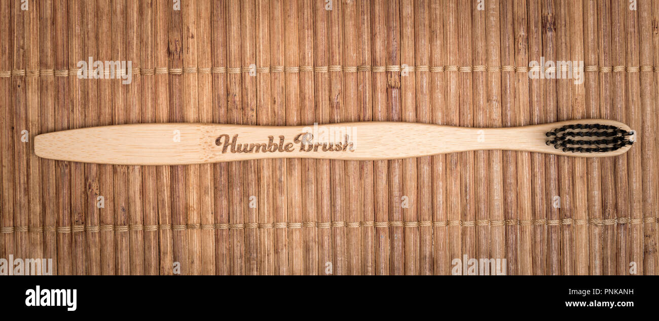 Humble brush, bamboo toothbrush with black nylon bristles on tablemat ...