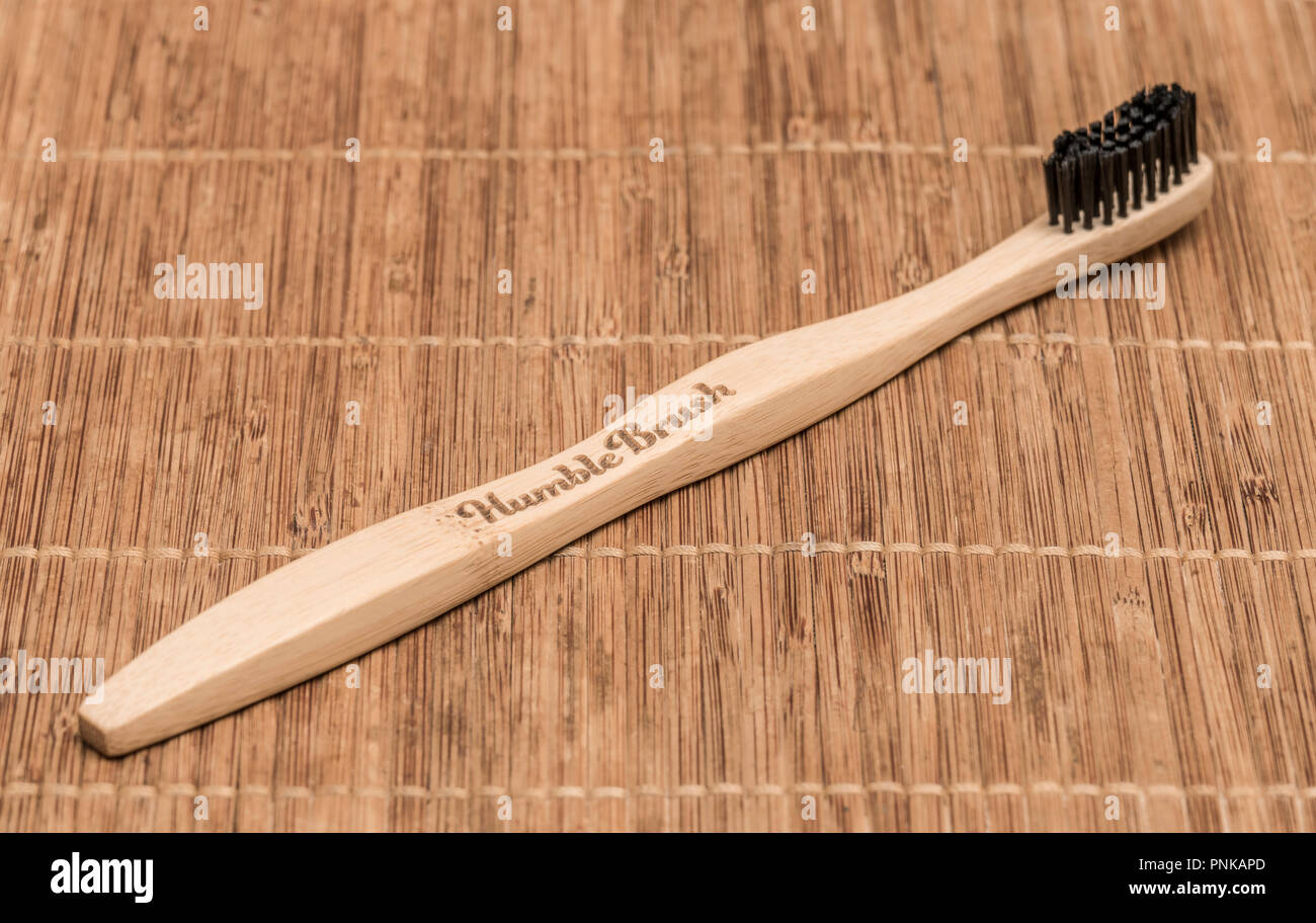 Humble brush, bamboo toothbrush with black nylon bristles on tablemat ...