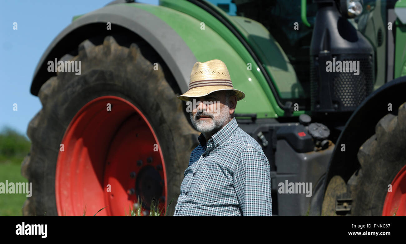 portrait of a farmer with tractor on background Stock Photo - Alamy