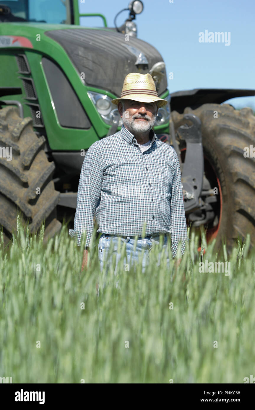 portrait of a farmer with tractor on background Stock Photo - Alamy