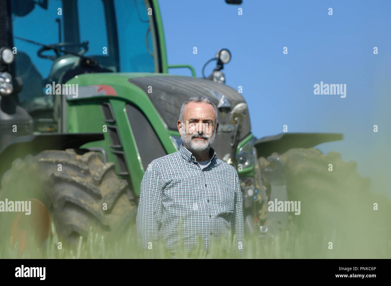 portrait of a farmer with tractor on background Stock Photo - Alamy