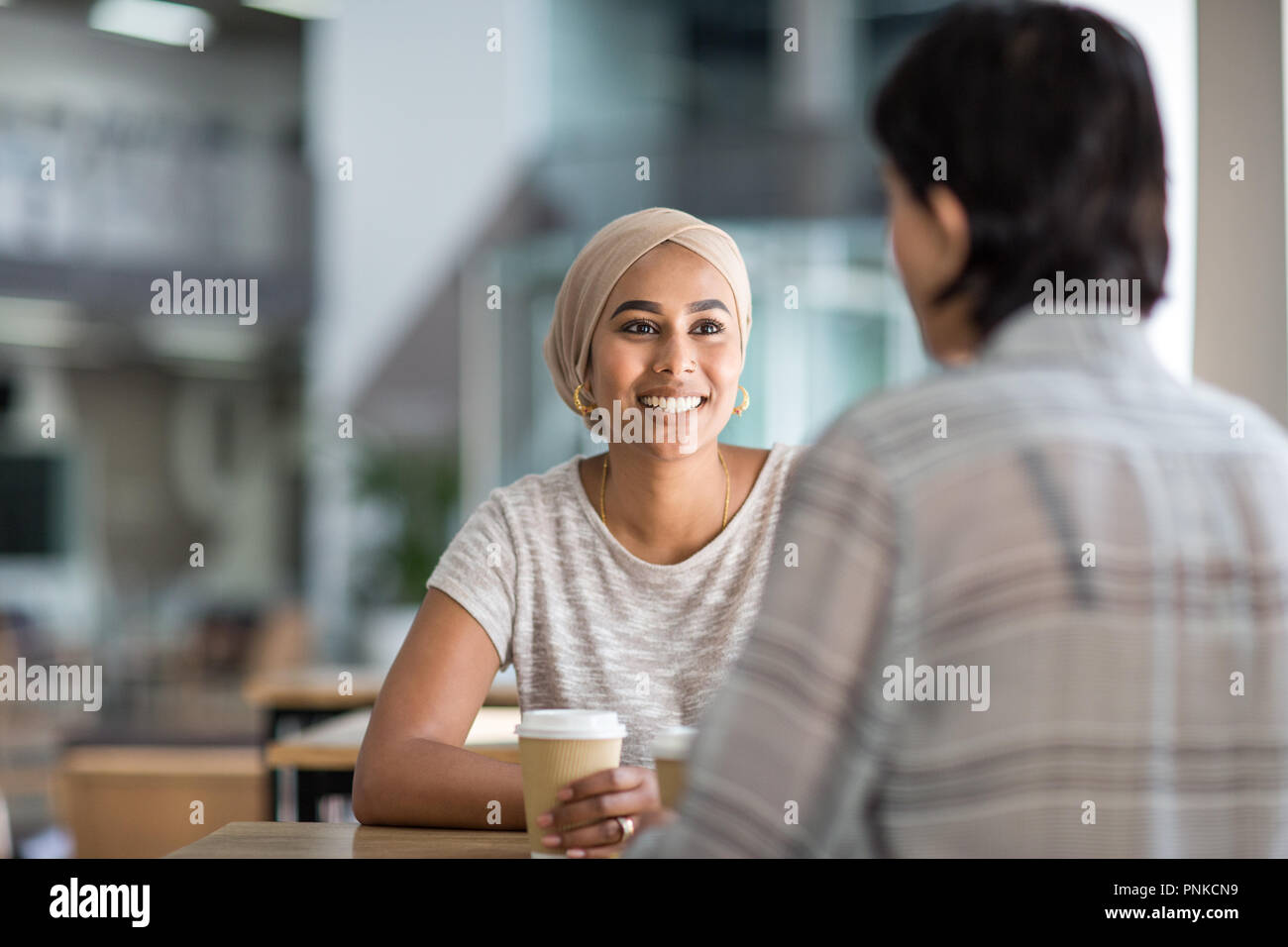 Female Muslim friends having coffee together in a shopping mall Stock ...