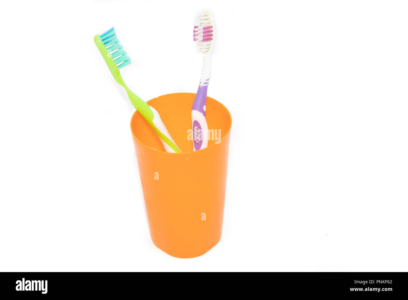 A toothbrush in a glass cup isolated on a white background. Care of ...