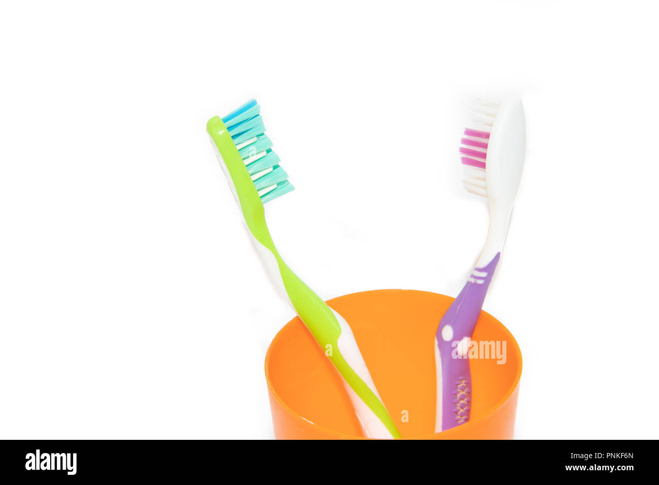 A toothbrush in a glass cup isolated on a white background. Care of ...