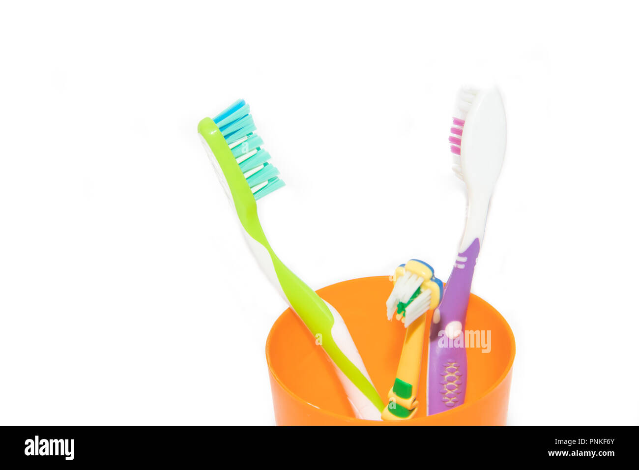 A toothbrush in a glass cup isolated on a white background. Care of ...