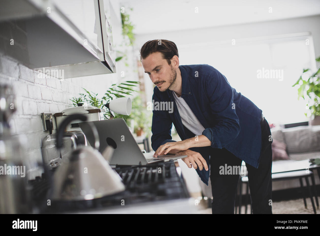Adult male working from home in kitchen Stock Photo - Alamy