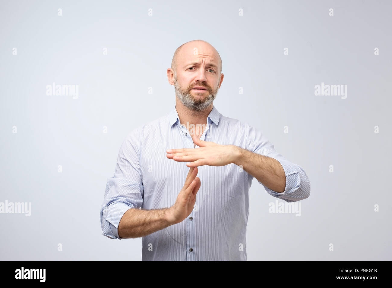 Mature man with beardnshowing time out hand gesture, asking to stop ...