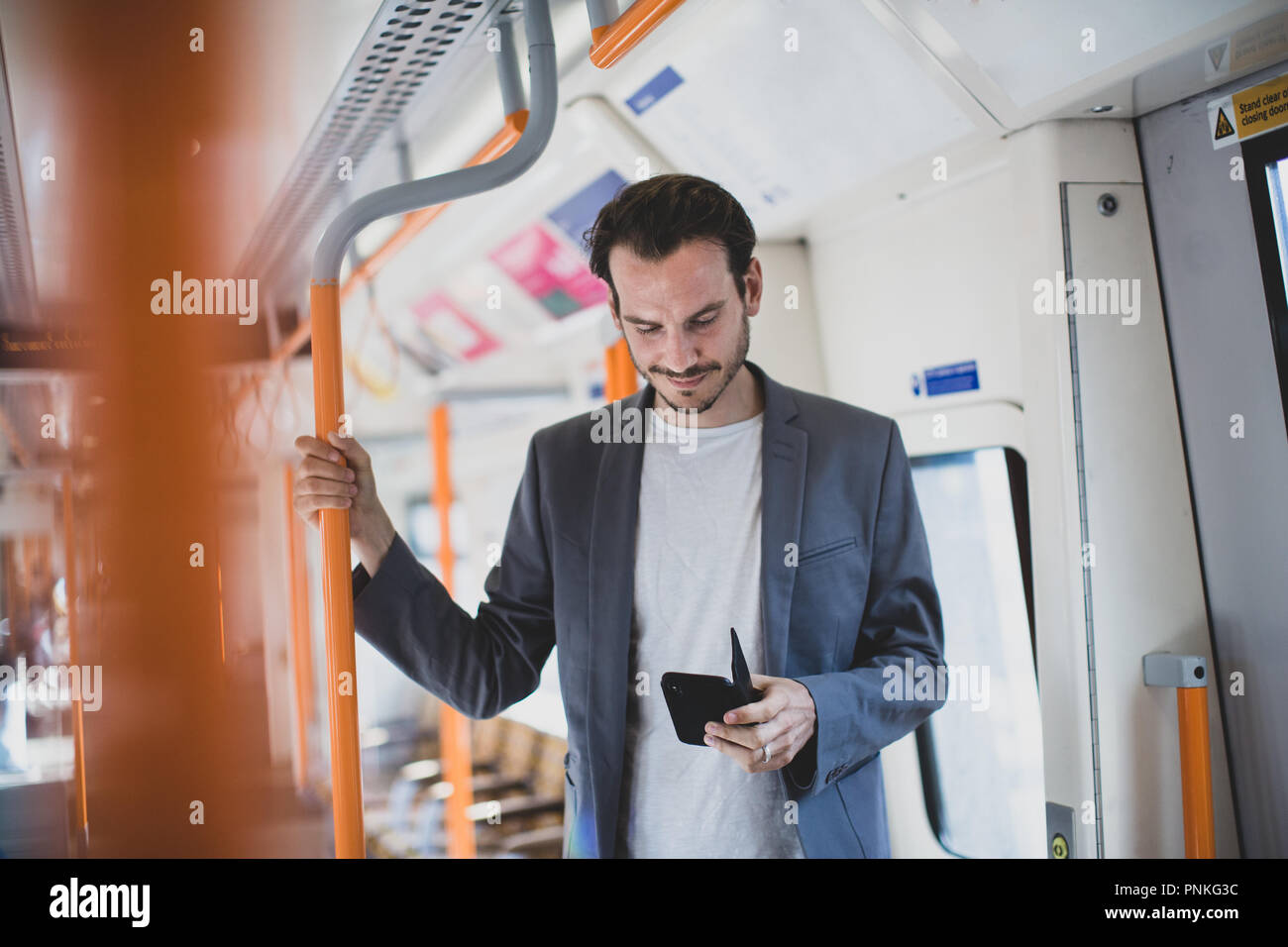 Checking smartphone male commuter hi-res stock photography and images ...