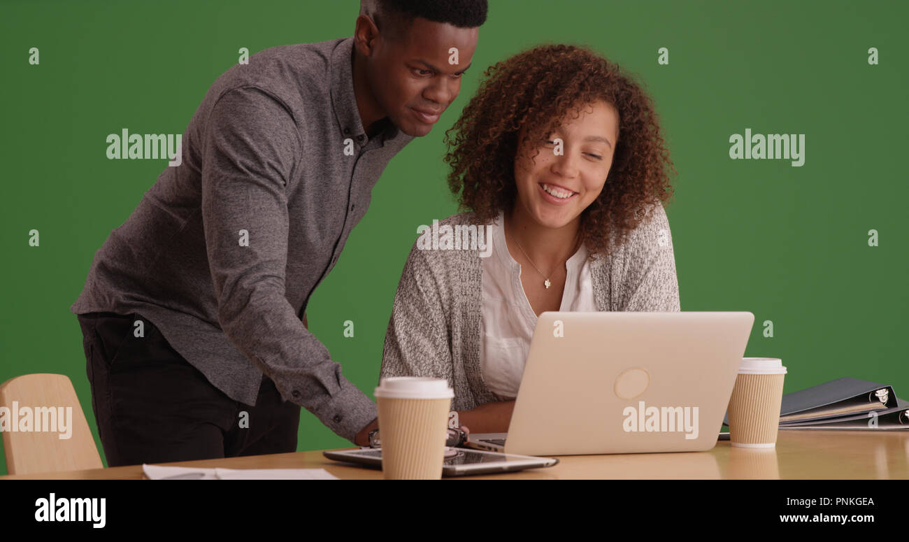 Young happy office co-workers using a computer on green screen Stock ...