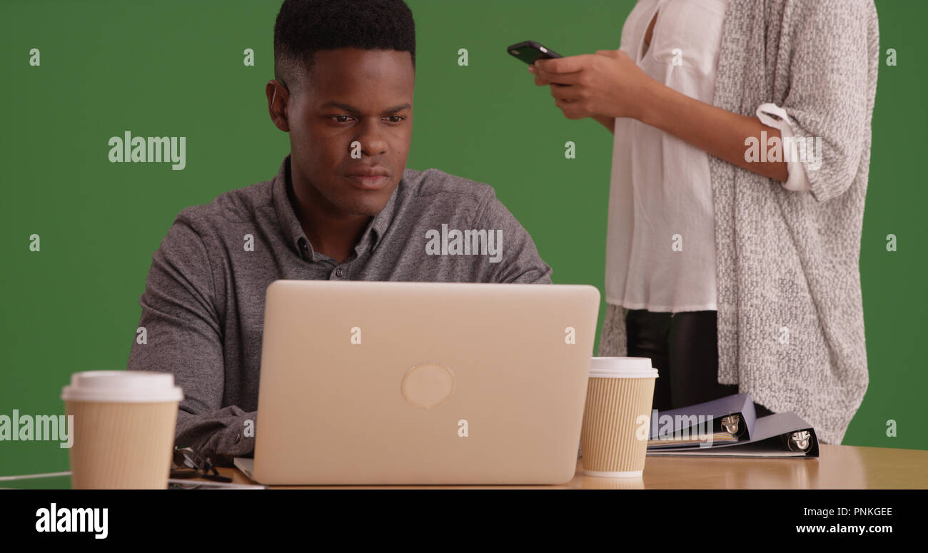 Millennials using phone and working on the computer on green screen ...
