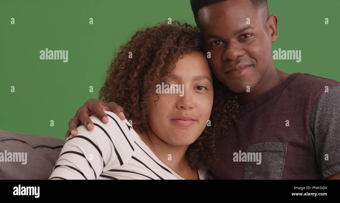 Couple poses for a portrait in their living room on their couch on ...
