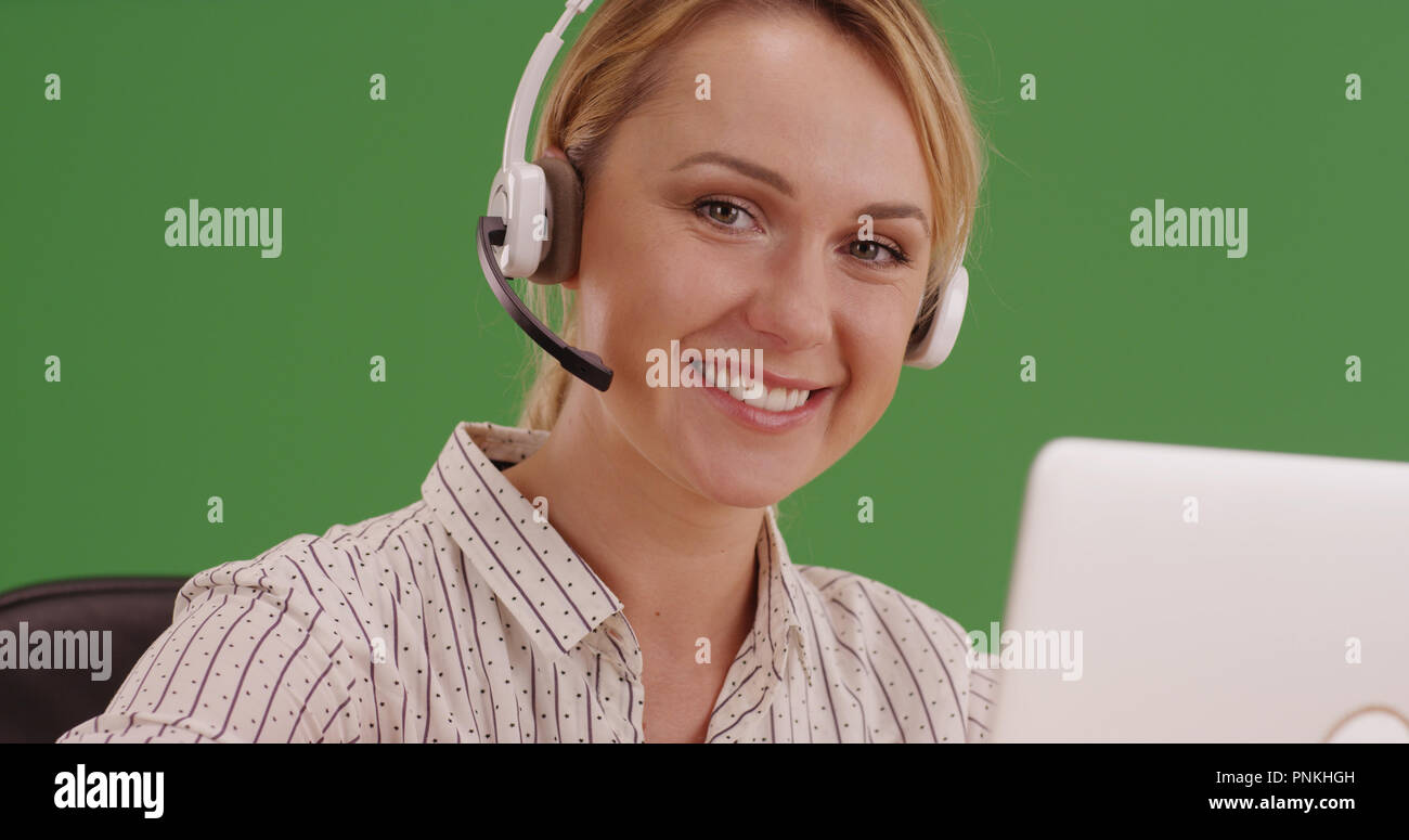 Friendly customer service representative smiling at camera on green ...