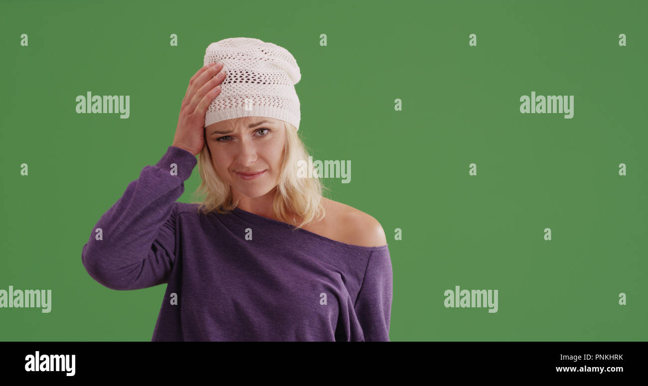 Silly woman rubbing head out of confusion on green screen Stock Photo ...