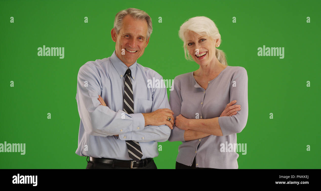Happy senior business professionals smiling at camera on green screen ...