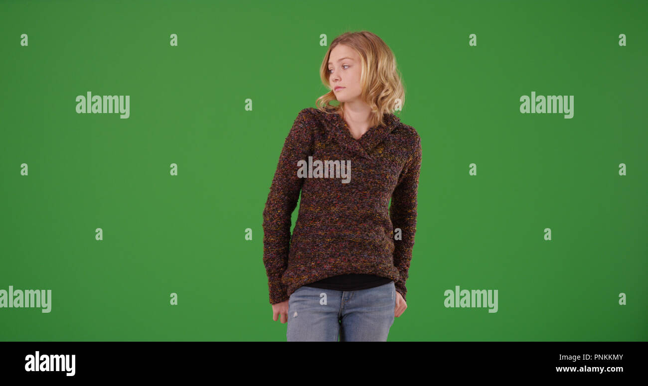 Bored young Caucasian woman standing around on green screen Stock Photo ...