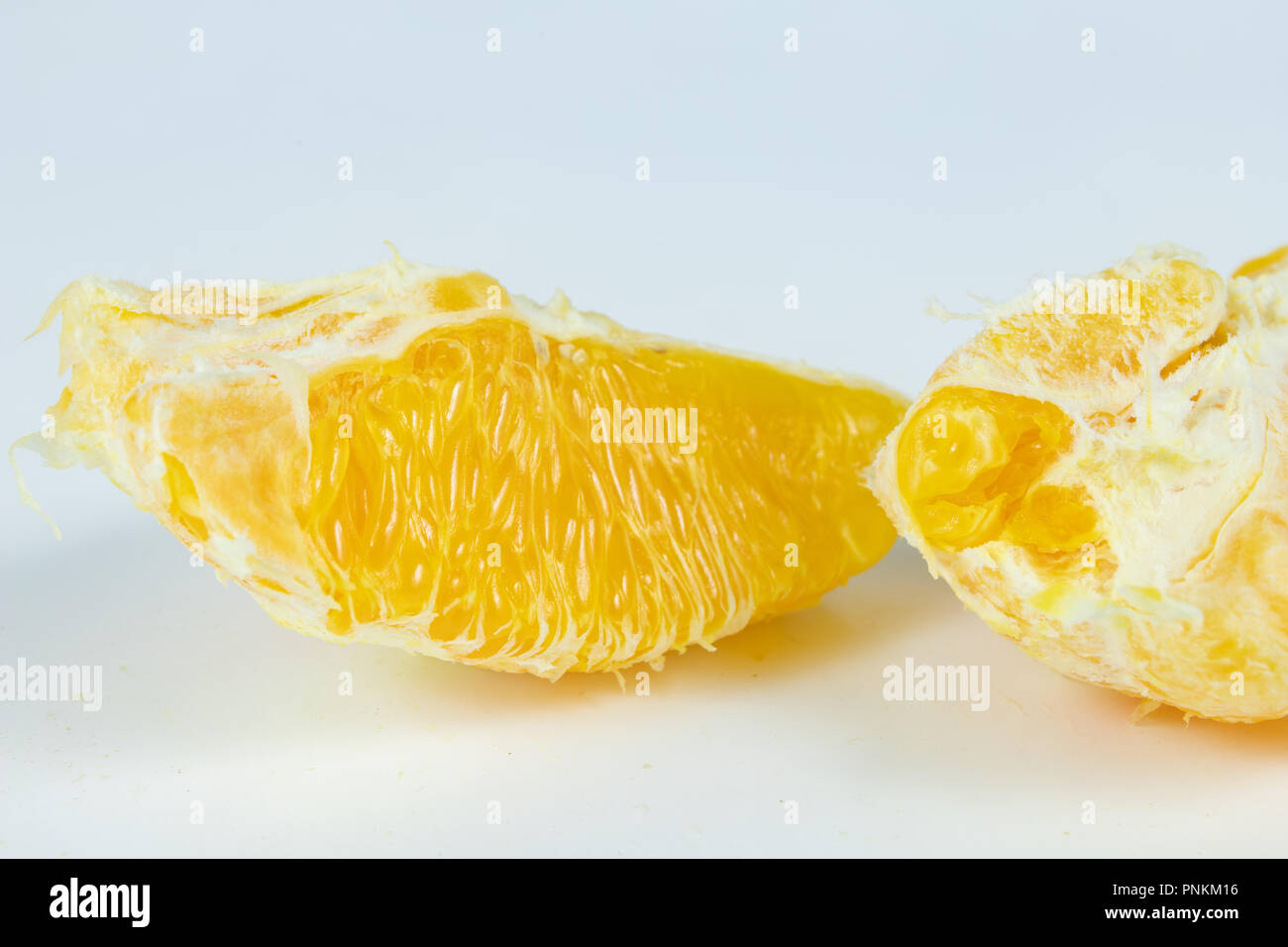 Peeled orange with very thick skin on a white kitchen table. Citruses ...