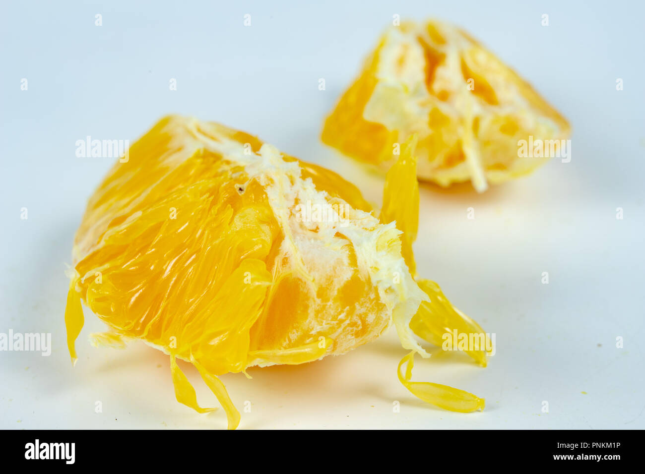 Peeled orange with very thick skin on a white kitchen table. Citruses ...