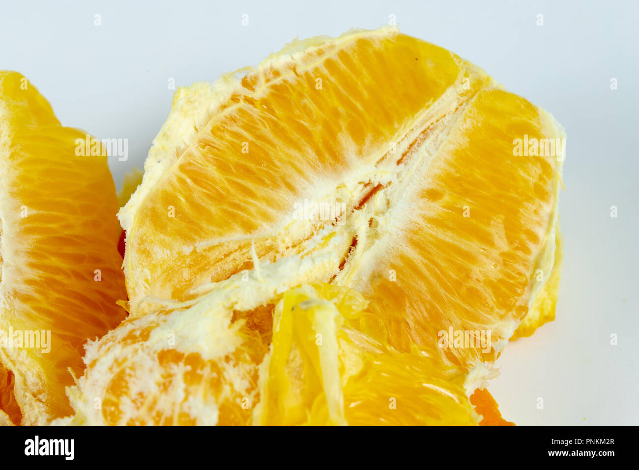 Peeled orange with very thick skin on a white kitchen table. Citruses ...